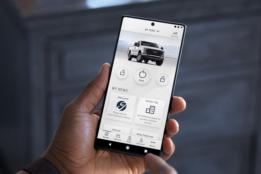Une personne se tient devant un VUS Ford Explorer® blanc tenant un ...