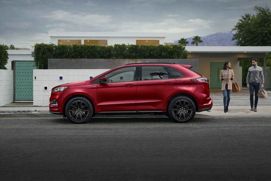 2023 Ford Edge® ST-Line model in Rapid Red parked in front of a modern ...