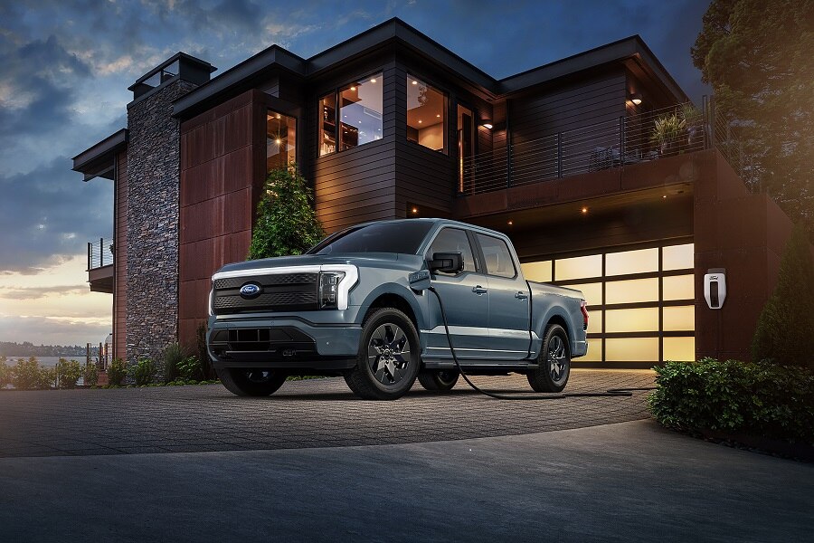 2023 Ford F-150® Lightning in Azure Gray parked in front of a home ...