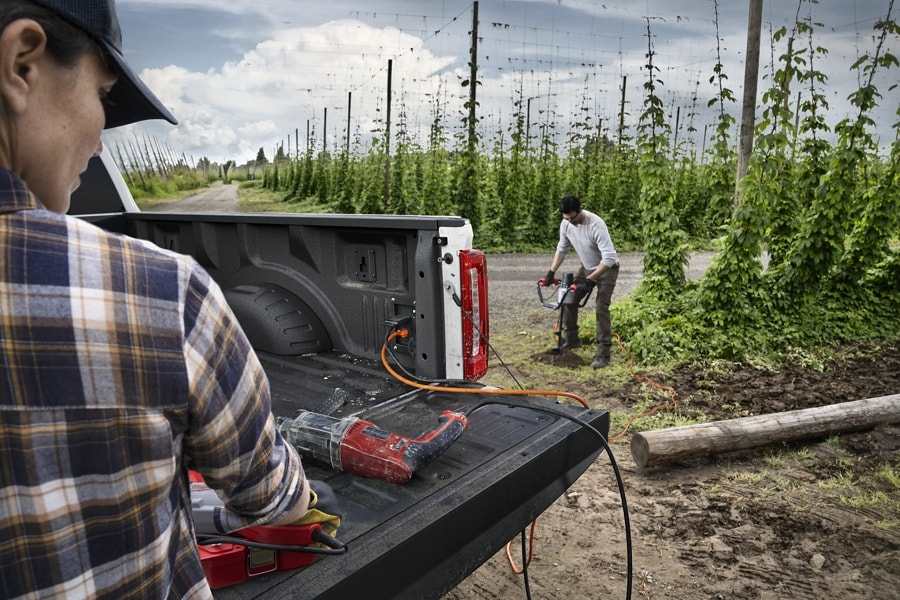 Two workers using the Pro Power Onboard feature on a 2023 Ford Super ...
