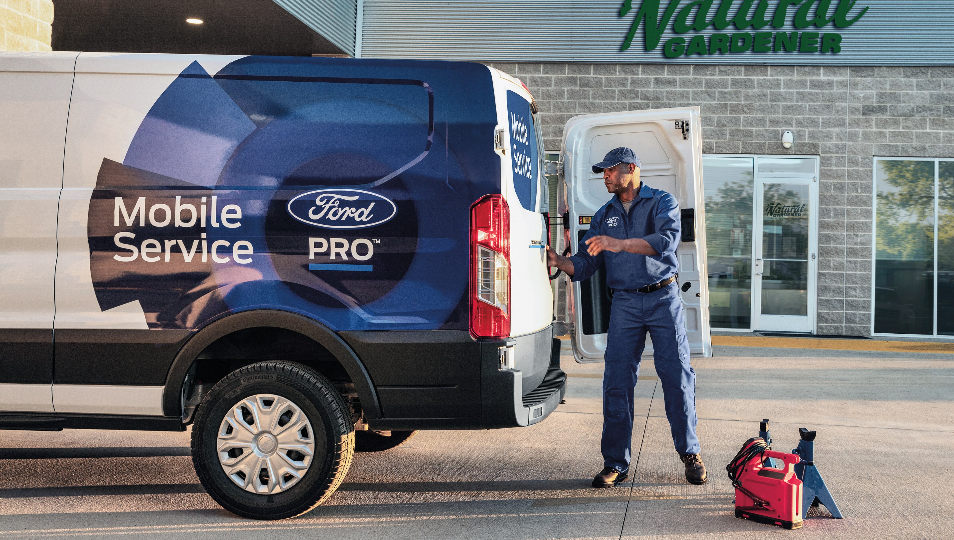 A Ford Pro mobile technician opening the back of a Ford Transit in ...