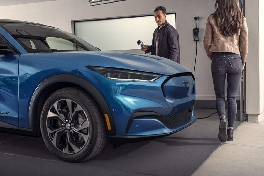 Couple charging a 2023 Ford Mustang Mach-E® in a garage